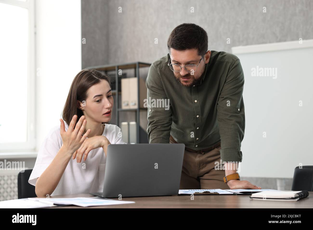 Consultant working with client at table in office Stock Photo - Alamy