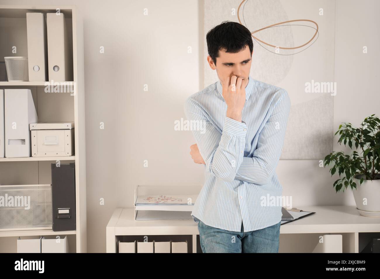 Portrait of embarrassed young man in office Stock Photo - Alamy