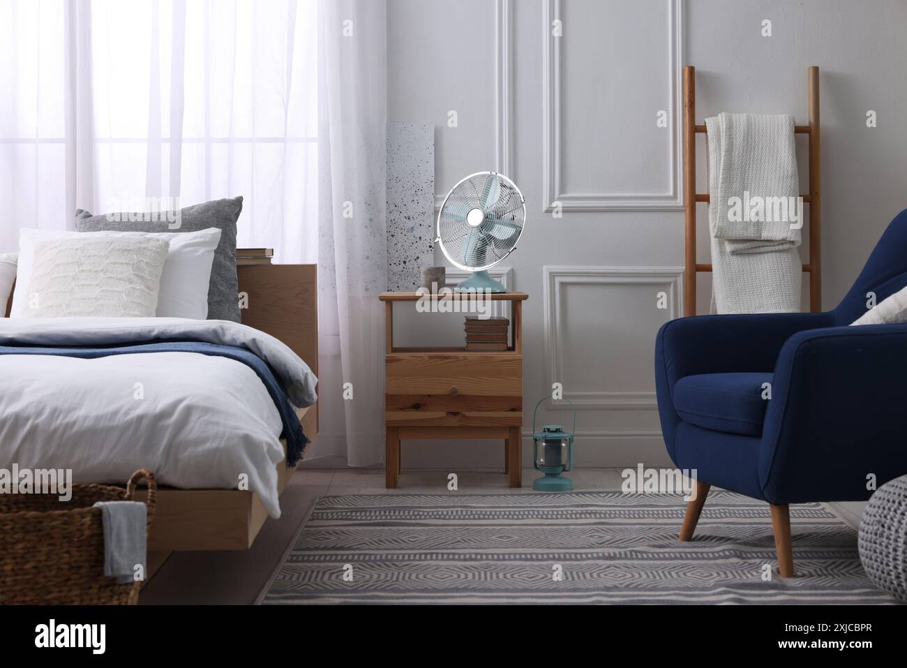 Stylish living room interior with bed, bedside table and fan Stock ...