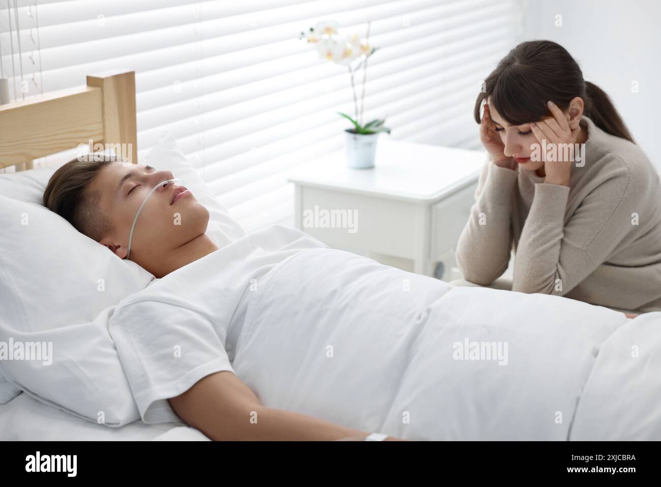 Coma patient. Sad young woman near her husband in hospital Stock Photo ...