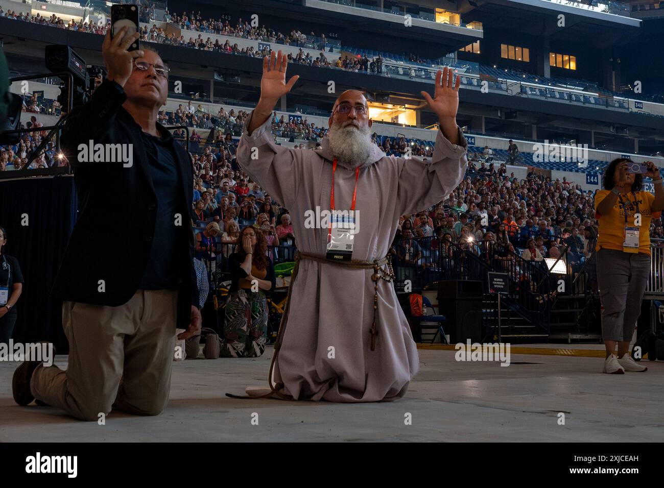 A priest kneels during a prayer at the National Eucharistic Congress ...