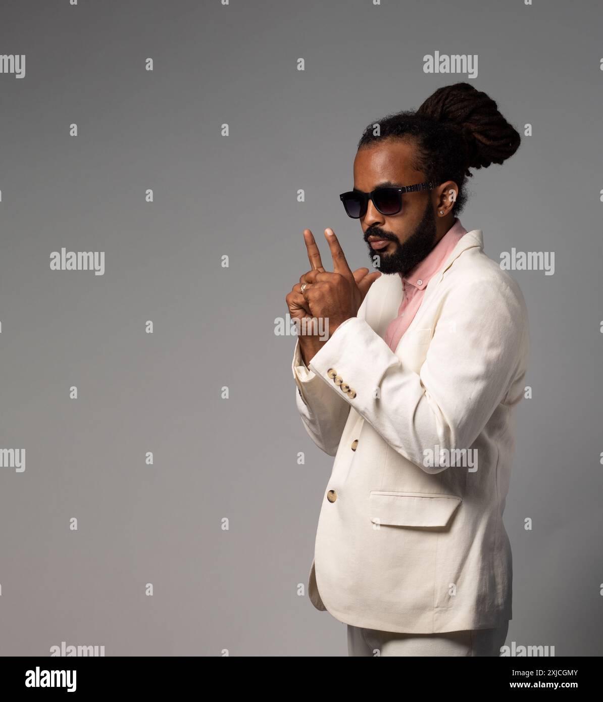 Stylish man latin with dreadlocks in white suit with sunglasses poses ...
