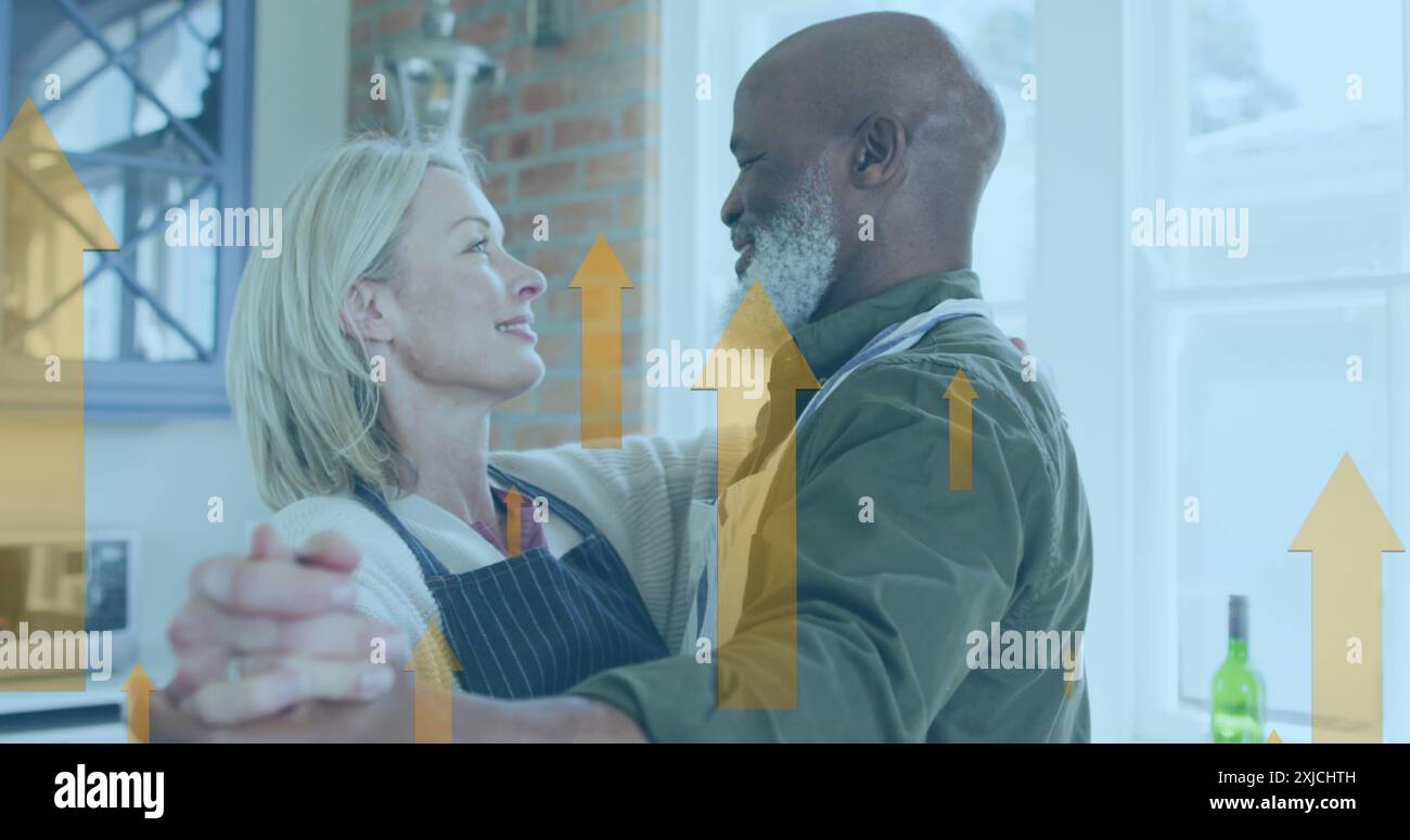 Image of multiple up arrow over diverse couple dancing wearing apron at ...