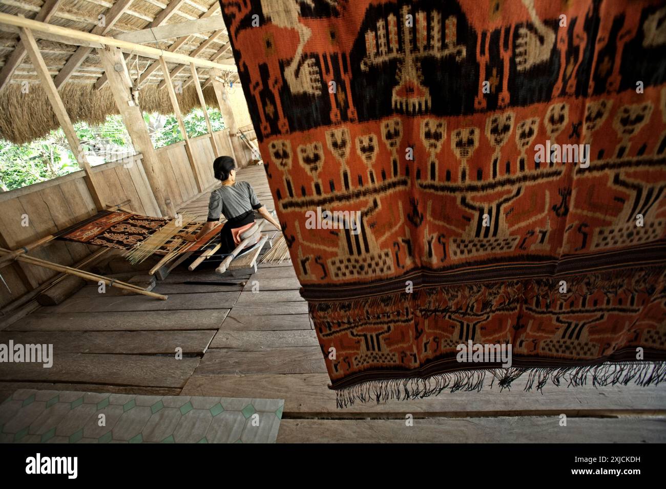 A woman weaving traditional woven fabric in traditional village of ...
