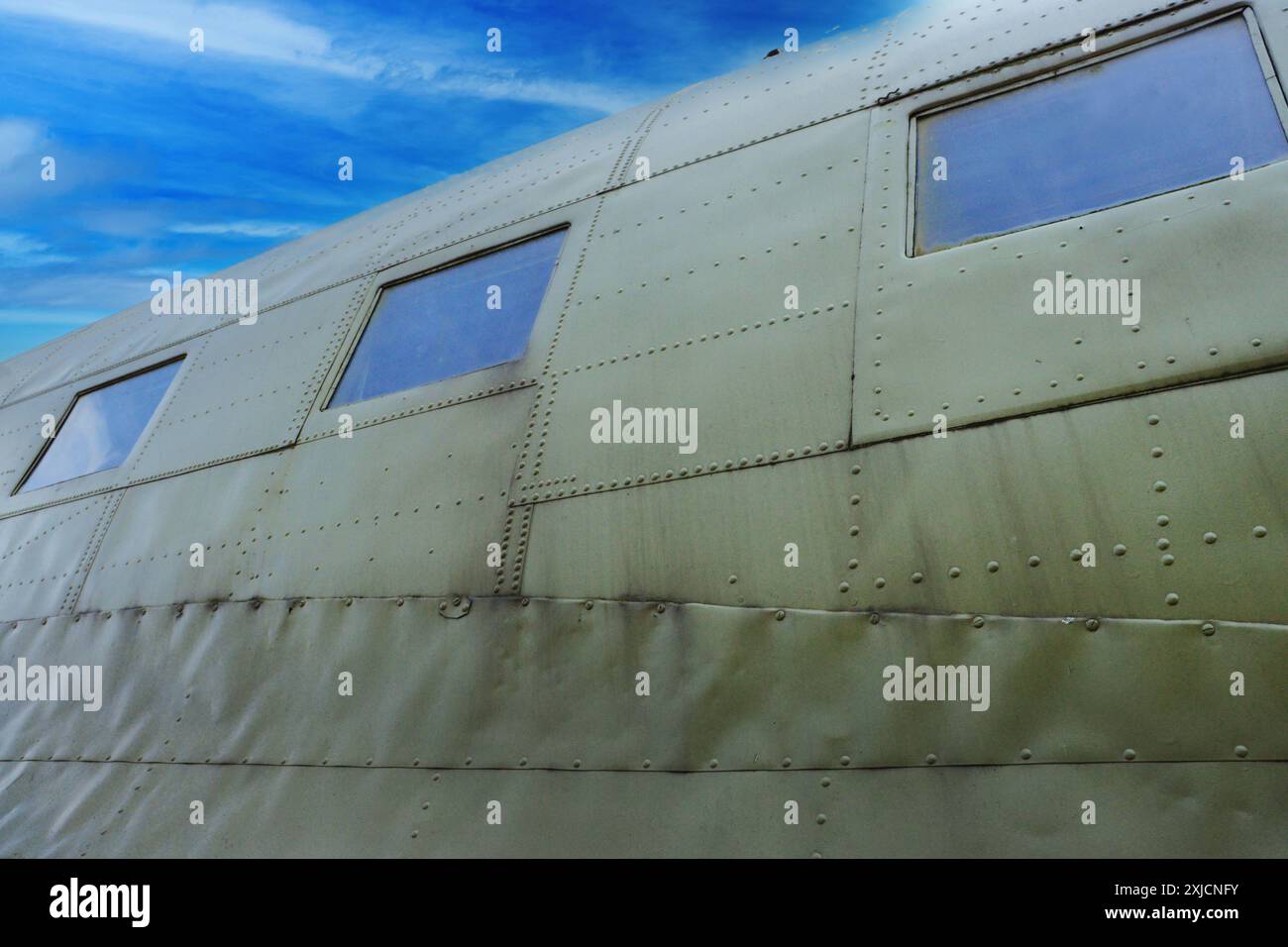 A fragment of the side of an old military airplane with three square ...
