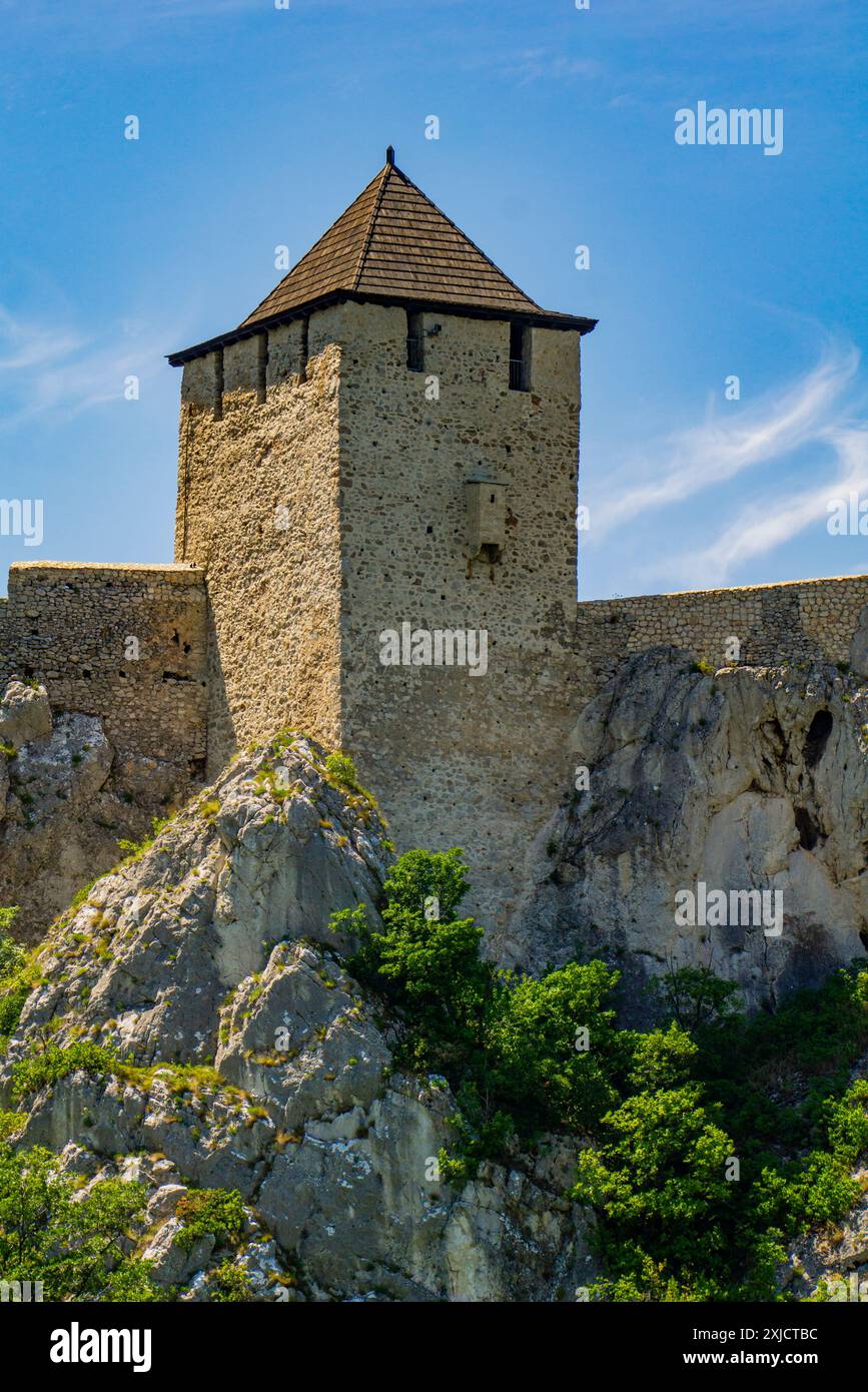 Storied tower of Golubac Fortress overlooks the rocky cliffs and lush ...