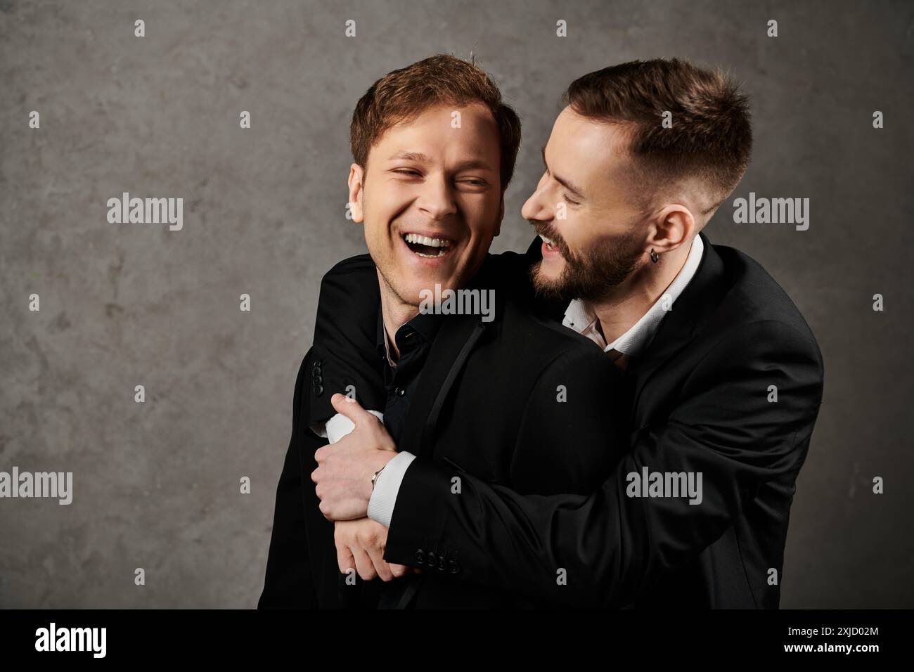 Two men in suits embrace and laugh together Stock Photo - Alamy