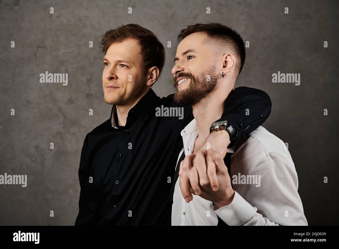 A gay couple in dapper suits embrace each other in a loving moment ...