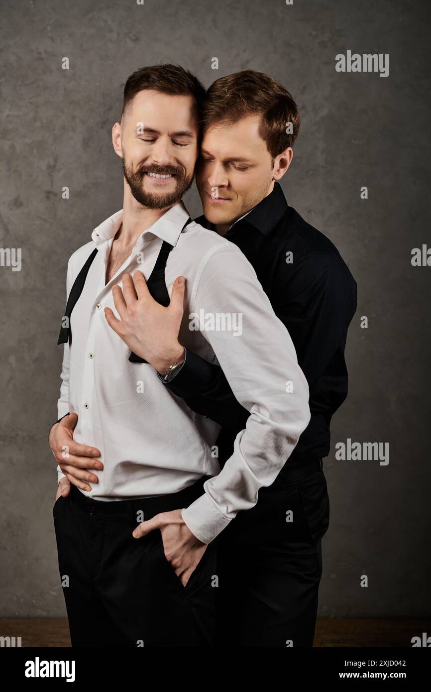 Two men in dapper suits embrace lovingly in a studio setting Stock ...