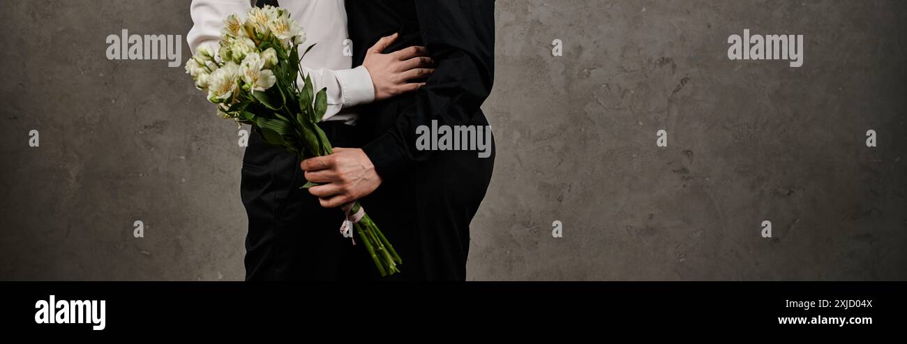 Two men in sharp suits embrace, one holding flowers Stock Photo - Alamy