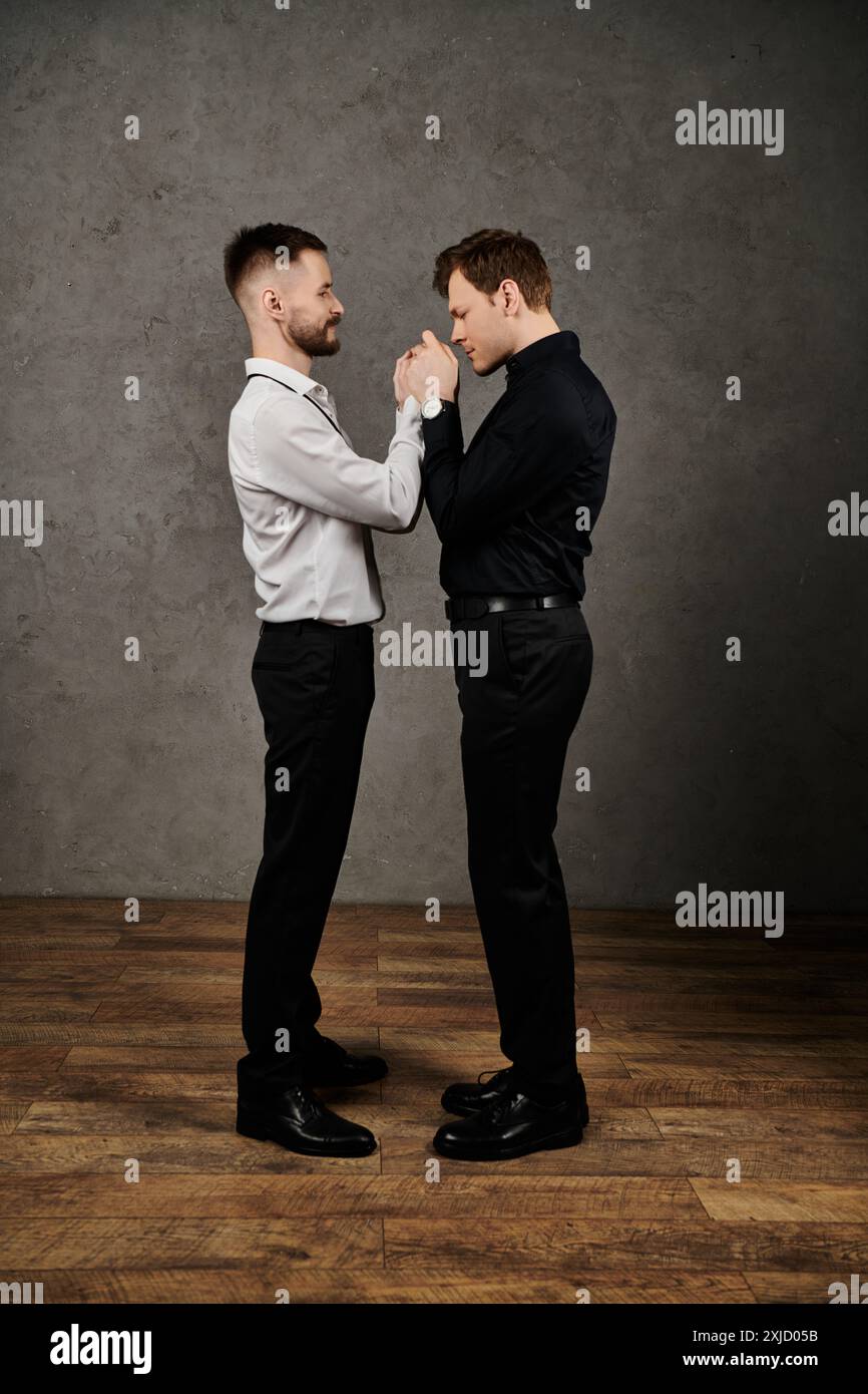 Two men in suits stand close, holding hands Stock Photo - Alamy