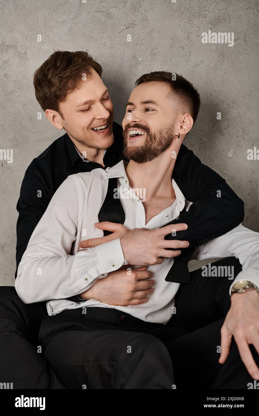 A loving gay couple in elegant suits embraces and laughs together Stock ...