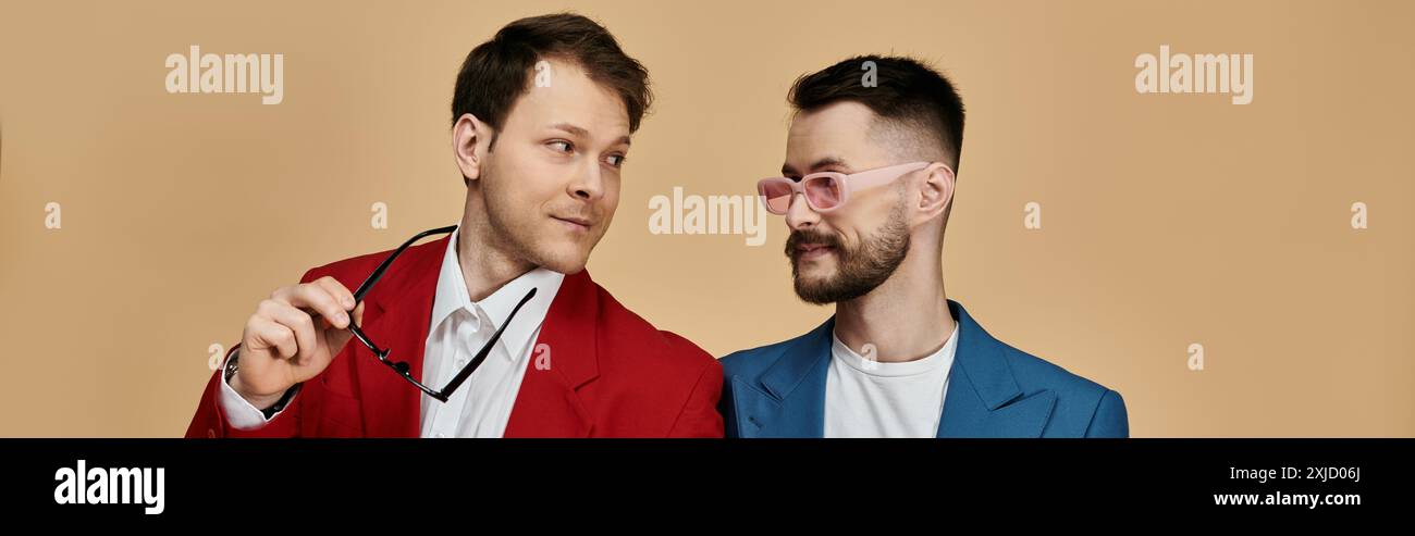 Two men in suits, one in red and one in blue, gaze at each other with ...