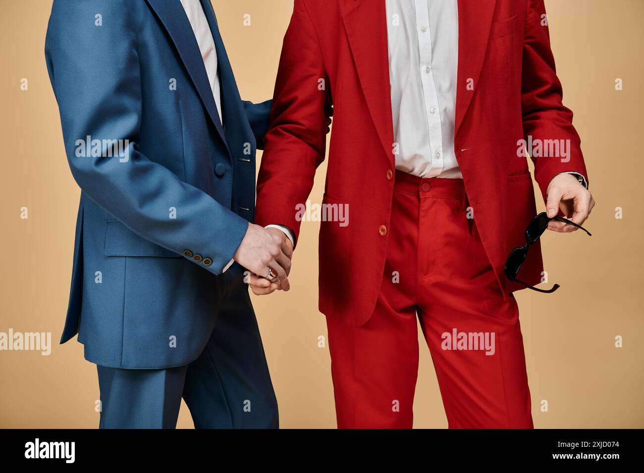 Two men in suits hold hands and stand side by side Stock Photo - Alamy