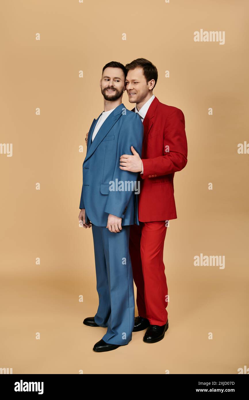 Two men in suits, one in blue and one in red, smile at each other Stock ...