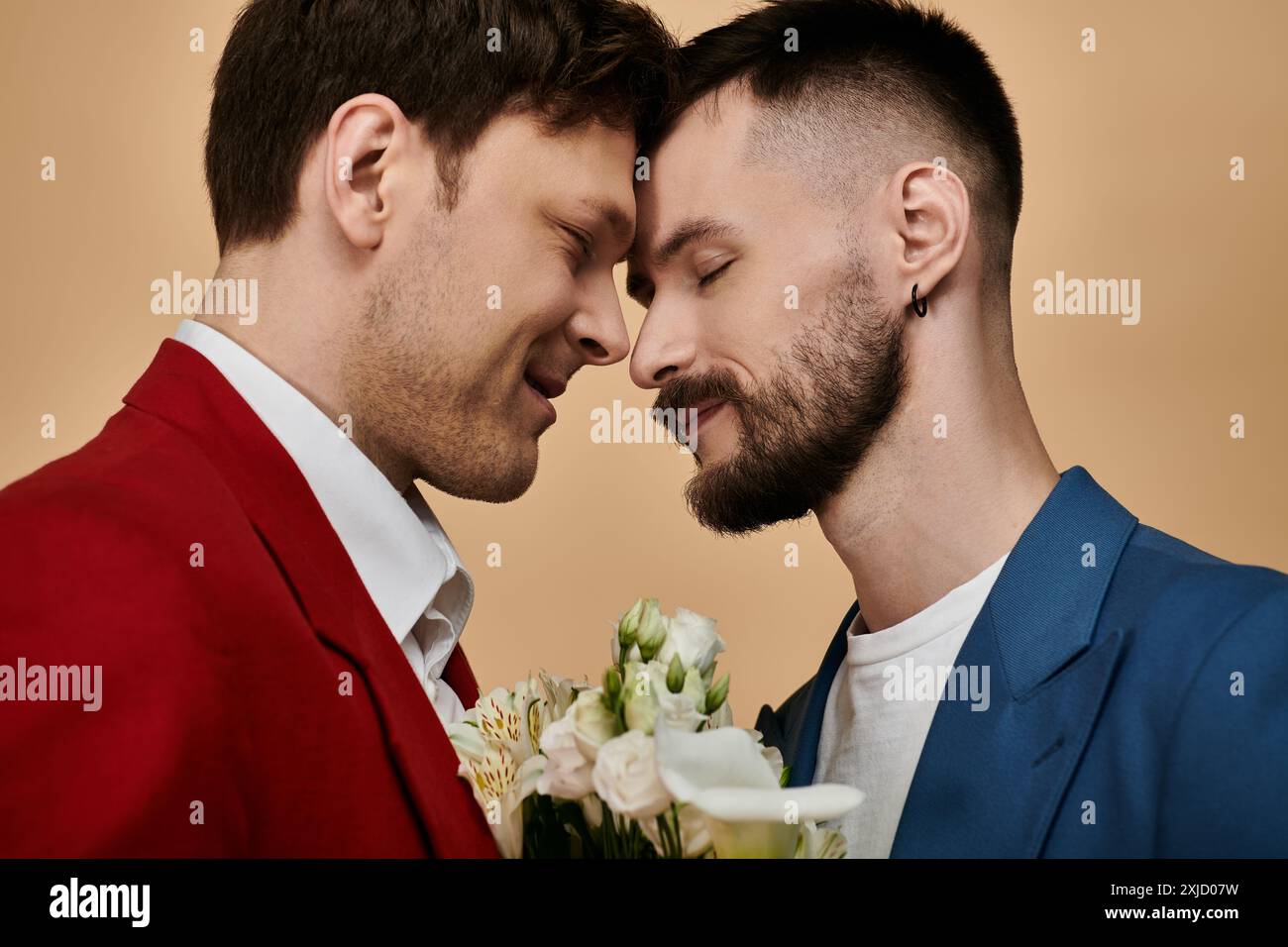 Two men in elegant suits share a loving moment, their foreheads ...