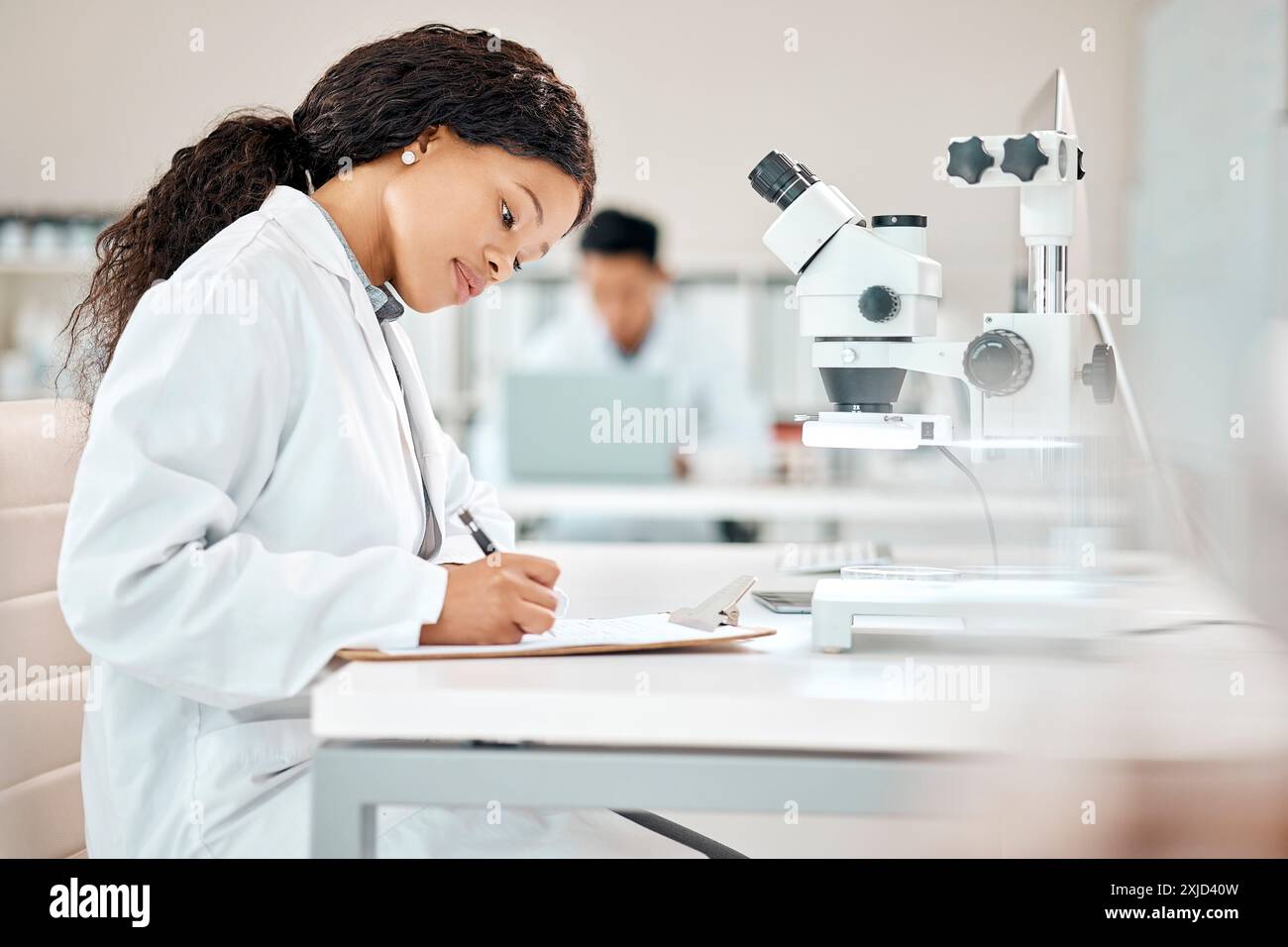 Science, woman and writing with microscope in laboratory for ...
