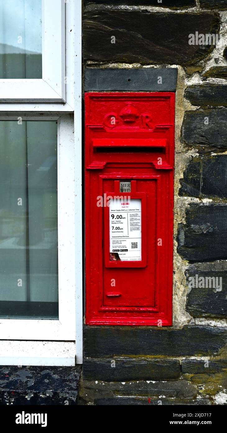 Royal Mail post box set in stone next to window, the box is red with GR ...