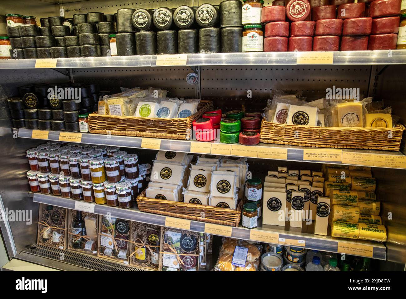 Cheddar cheeses on display inside cheese store shop in the English ...