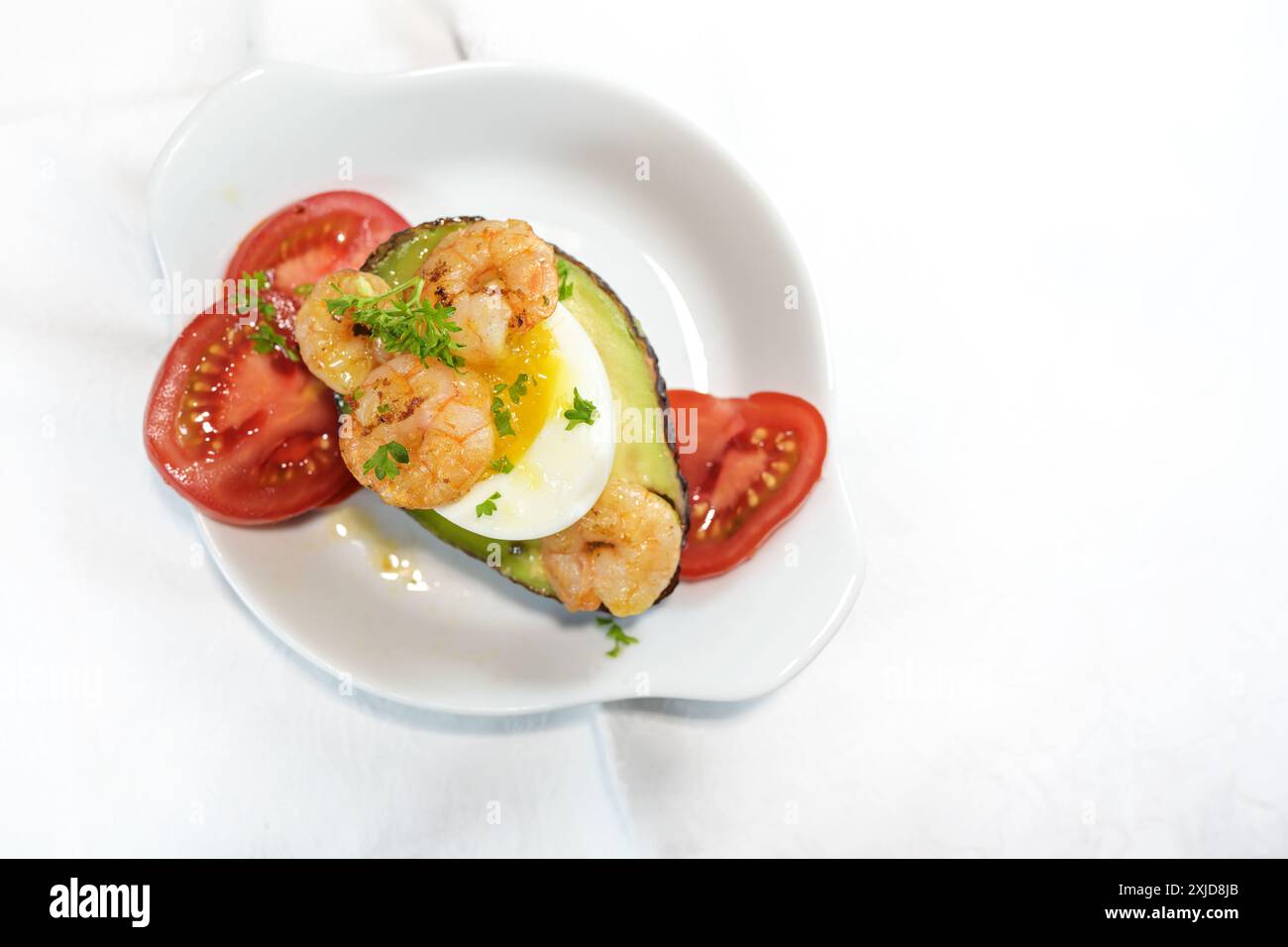 Shrimps, egg, avocado and tomato with parsley garnish, healthy low carb ...