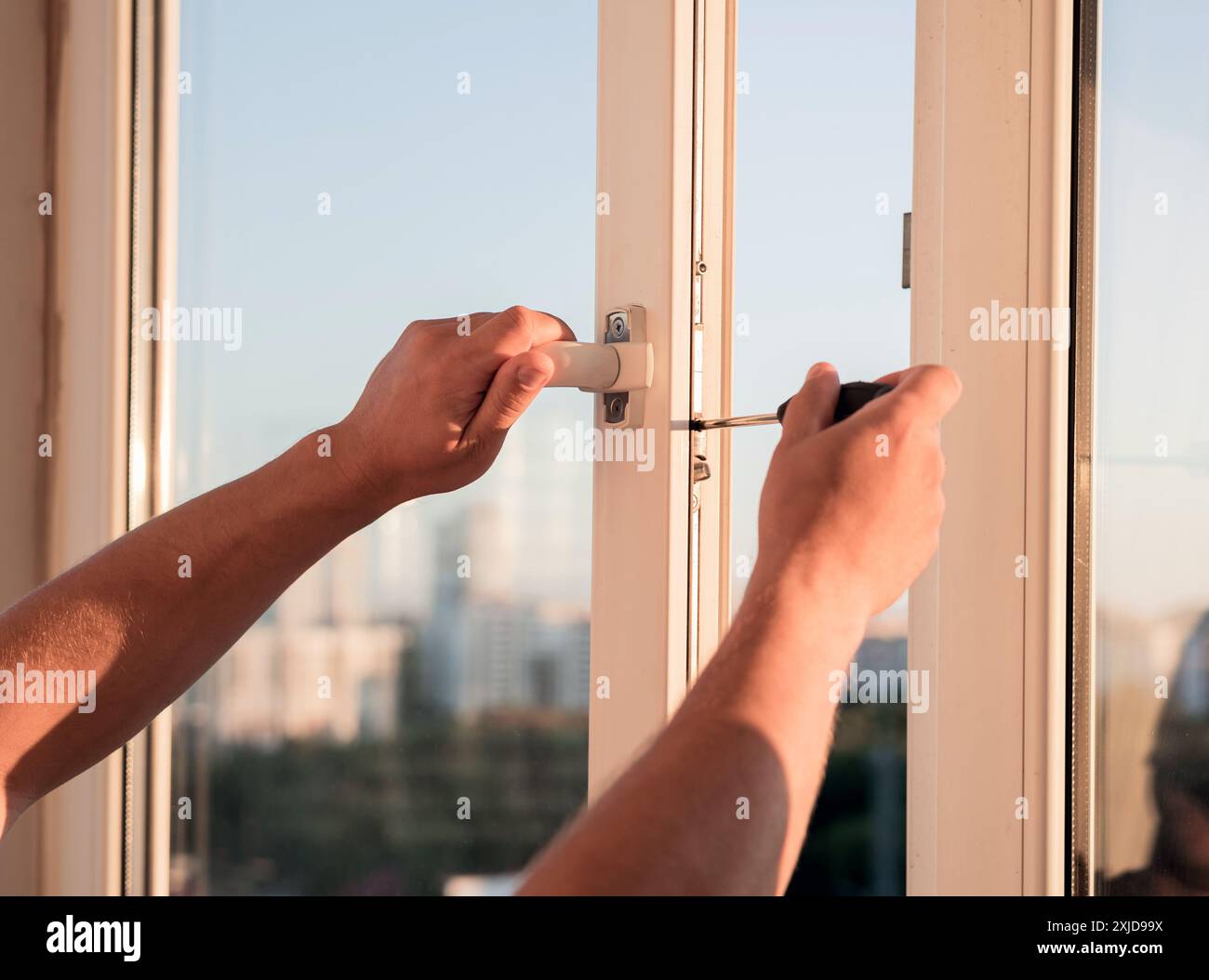 Handyman repairing the window on balcony. adjusting plastic windows ...