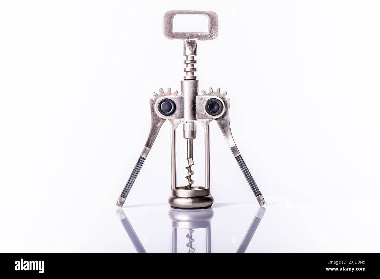 A textured, metal corkscrew stands upright in the centre of the image ...