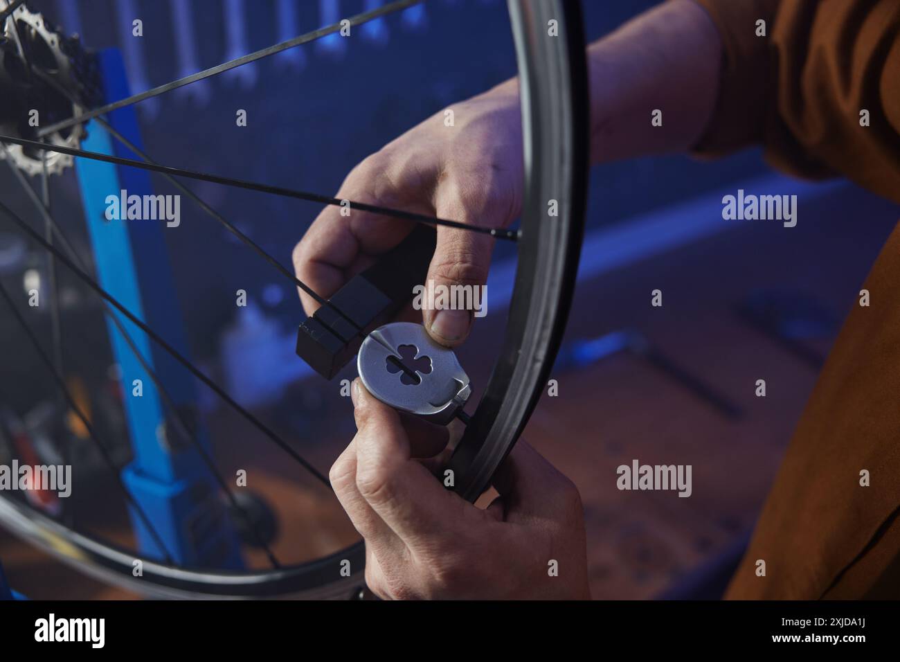 Repairman doing tensioning and alignment of bicycle spokes closeup view ...