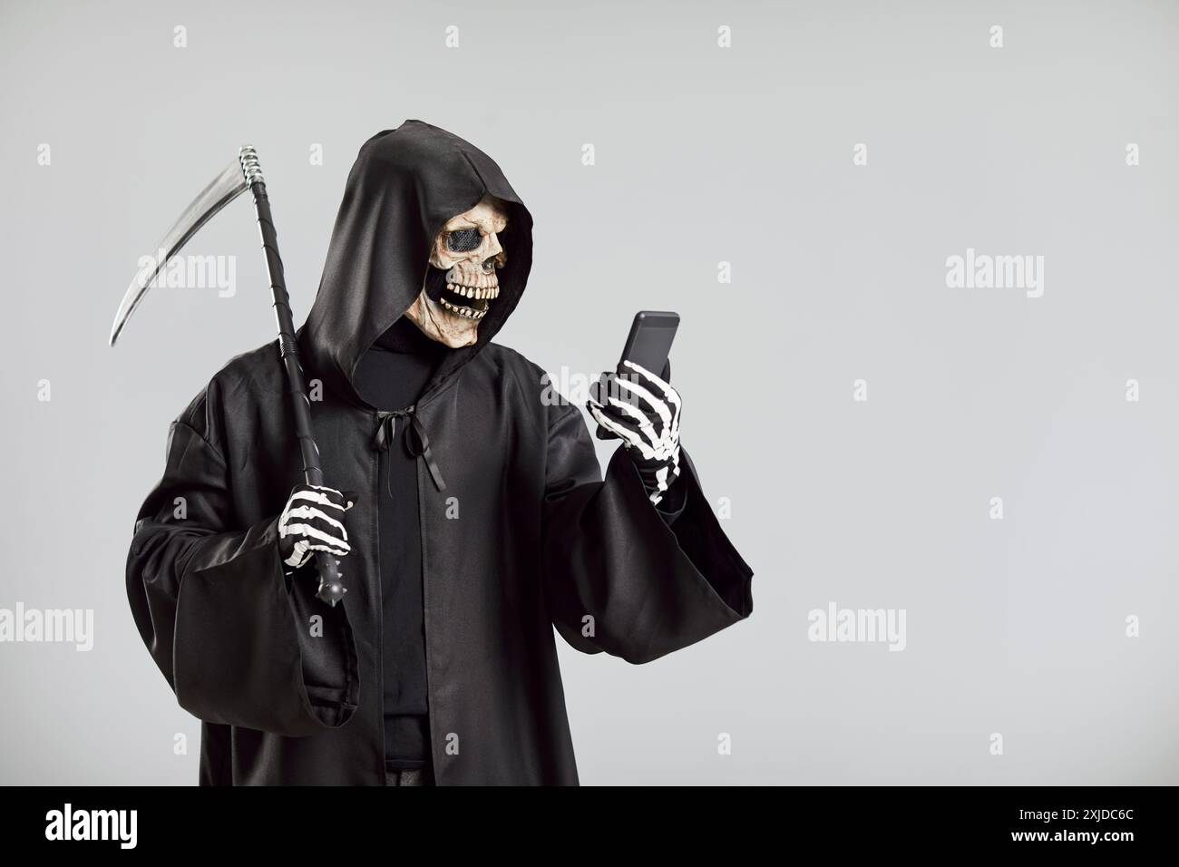 Grim Reaper Using Mobile Phone On Grey Background Stock Photo - Alamy