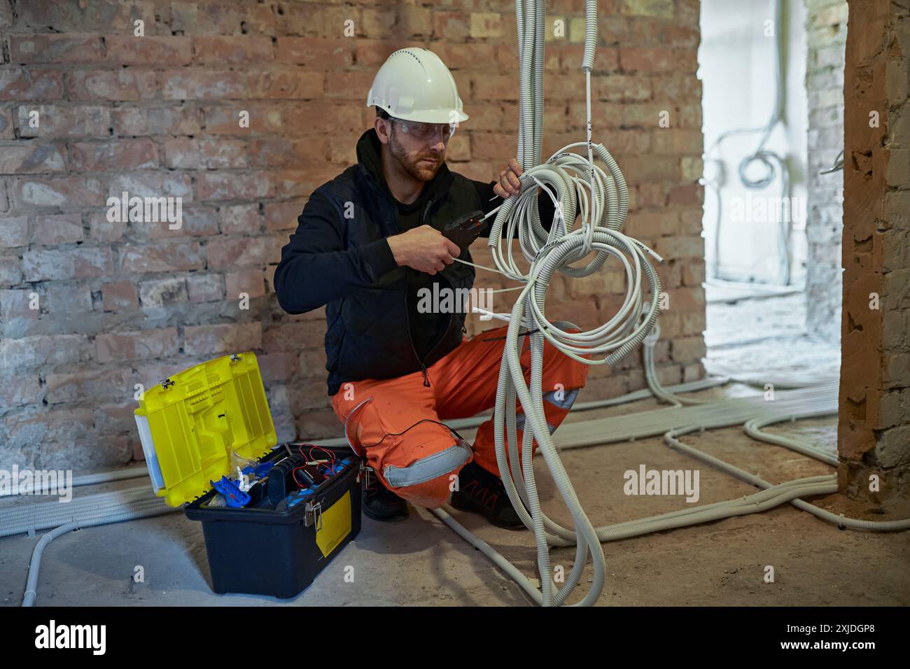 Electrical contractor working with multiple cables during installation ...
