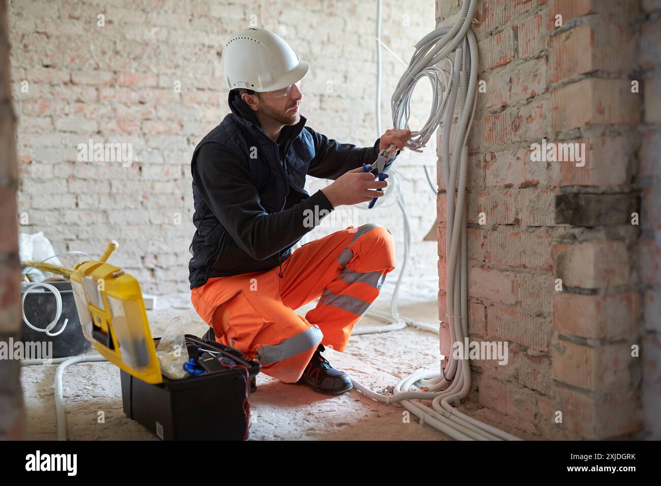 Electrical contractor working with cables on construction site during ...