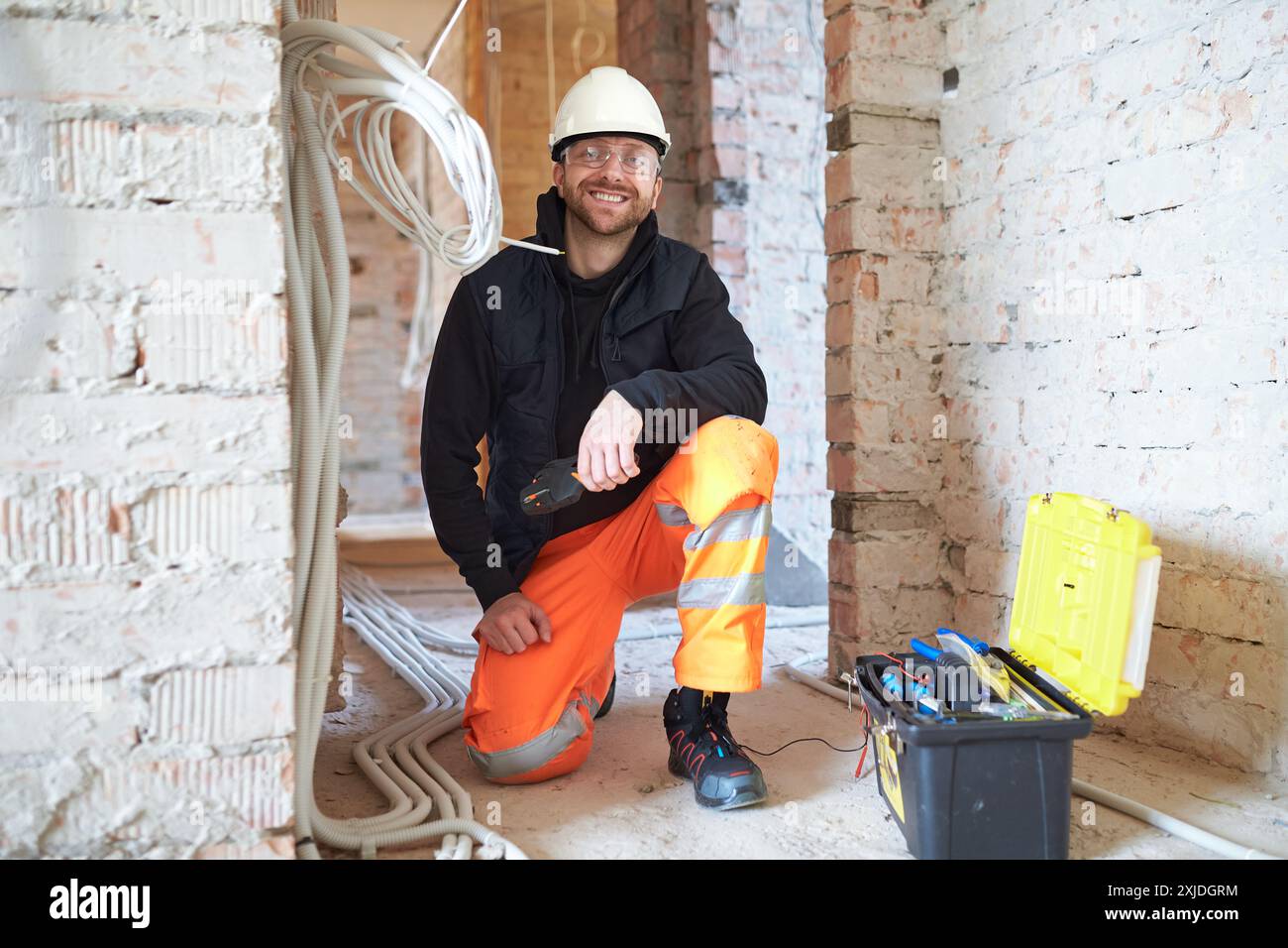 Portrait of young smiling electrical engineer on construction site ...