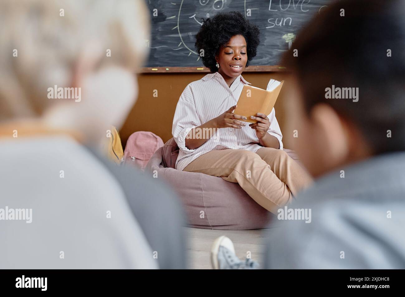 Mindful female teacher of Black ethnicity in bean bag chair against ...