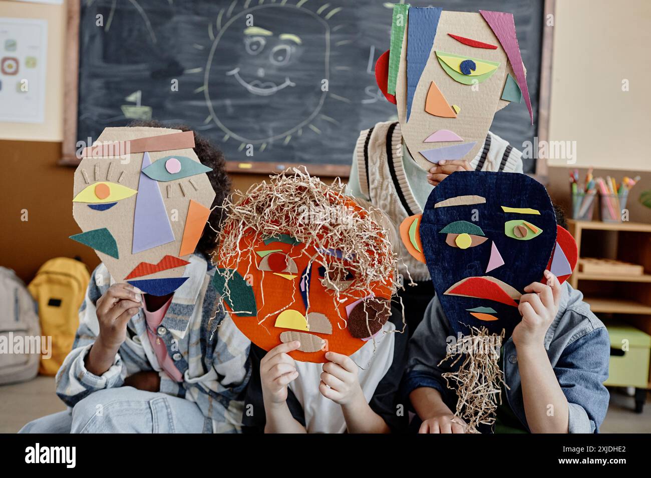 Shot of unrecognizable kids hiding behind cardboard face mask crafts in ...