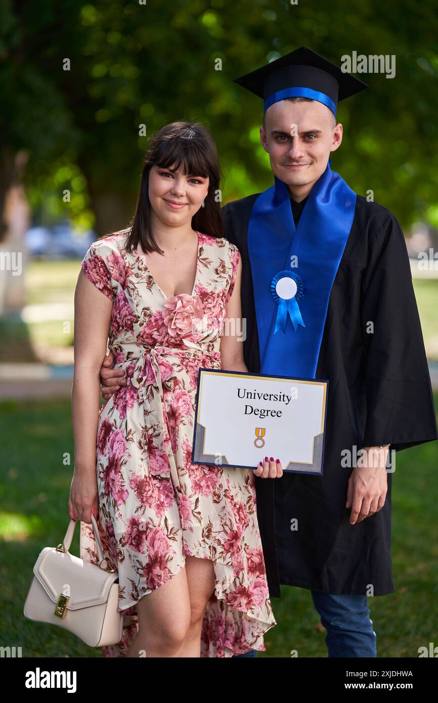 Young University graduate man in academic regalia and cap with his ...