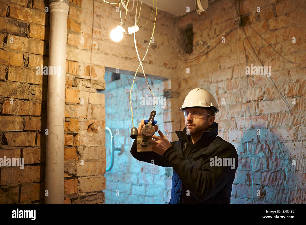 Electrical contractor working with cables on construction site during ...