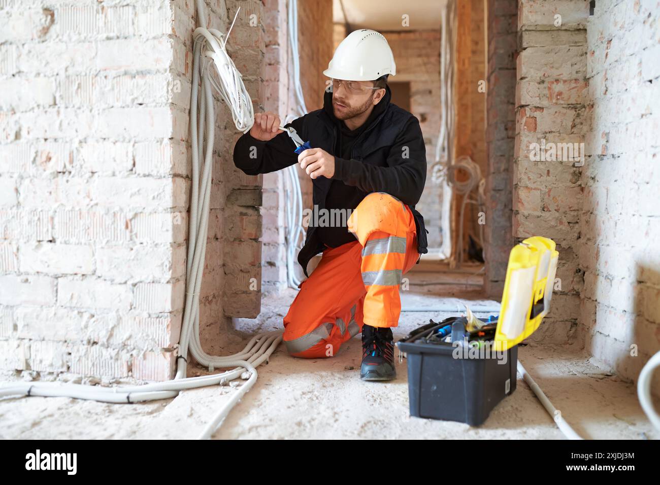 Electrical contractor working with cables on construction site during ...