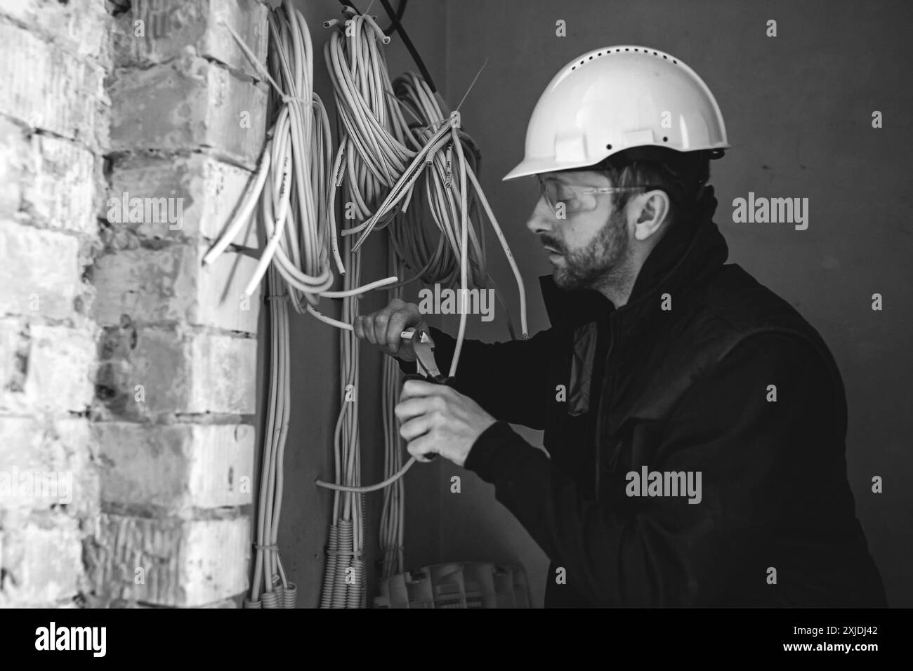 Black-and-white photo showing Electrician at Work Stock Photo - Alamy