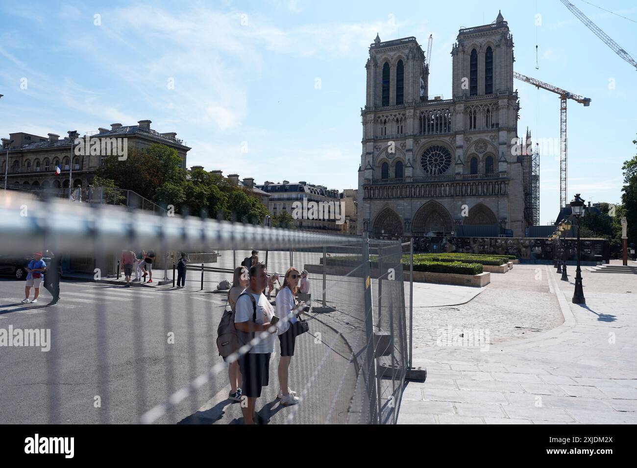 People watch Notre Dame cathedral from outside the security zone set up ...