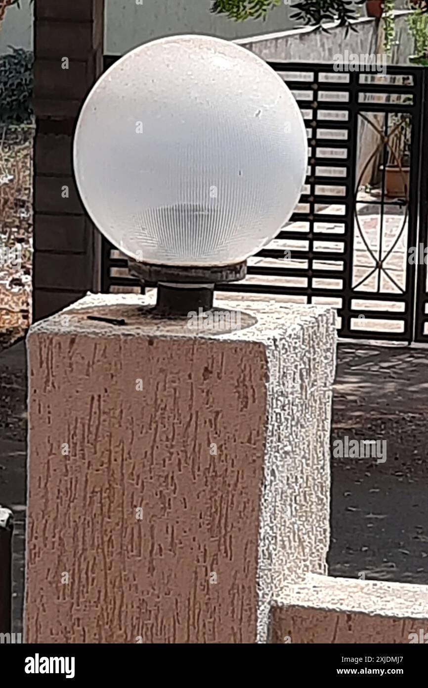 Close-up of white glass bulb covering electrical lamp fixed on top of ...