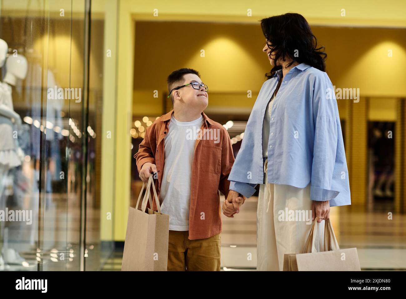 A mother and her son with Down syndrome walk hand-in-hand through a ...