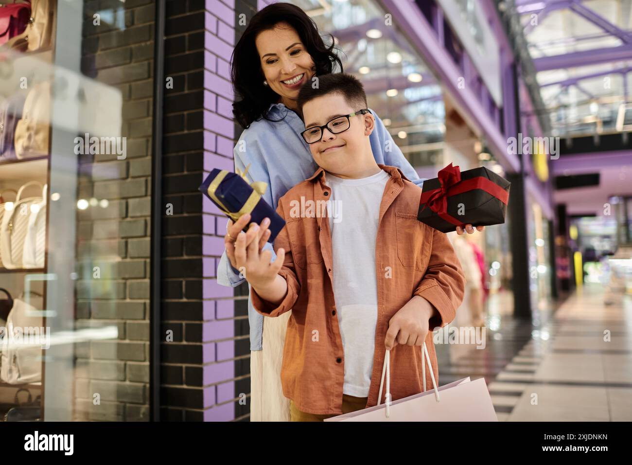 A mother and her son with Down syndrome walk through a shopping mall ...