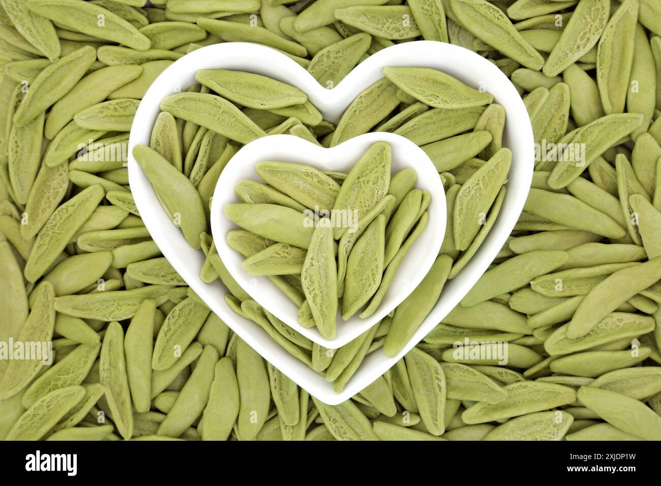 Italian foglie D'ulivo pasta background with two heart shape dishes ...