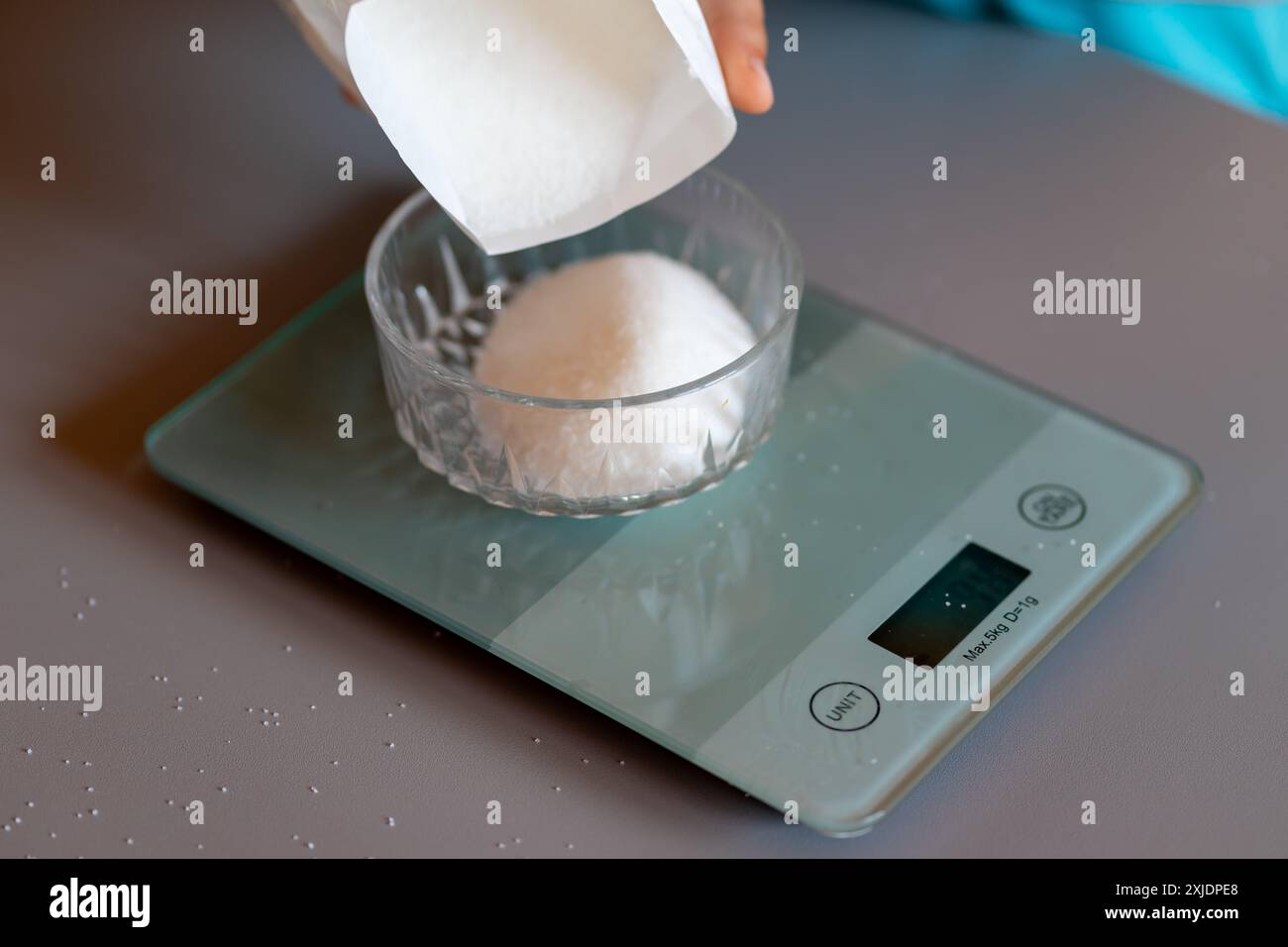Weighing sugar from a pack on a kitchen scale Stock Photo - Alamy