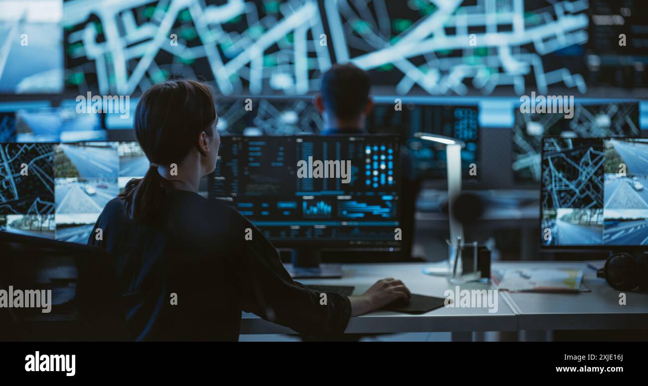 Back View Female Officer Using her Computer to Monitor Live CCTV ...