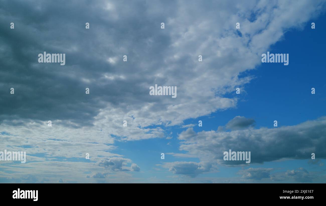 Time lapse. Clouds running across the blue sky. White puffy and fluffy ...