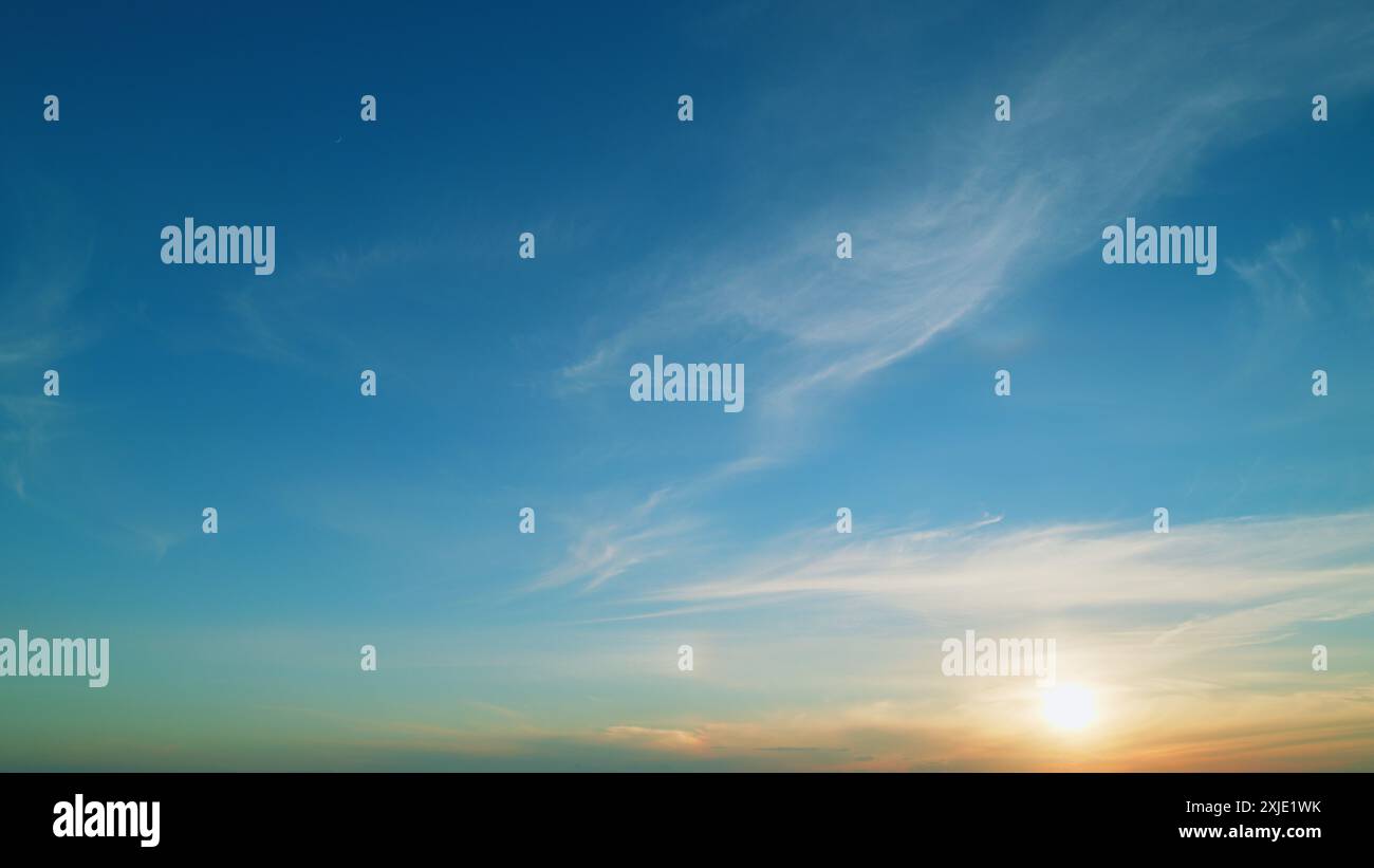 Time lapse. Beautiful blue and orange cloudy sunset sky with halo ...
