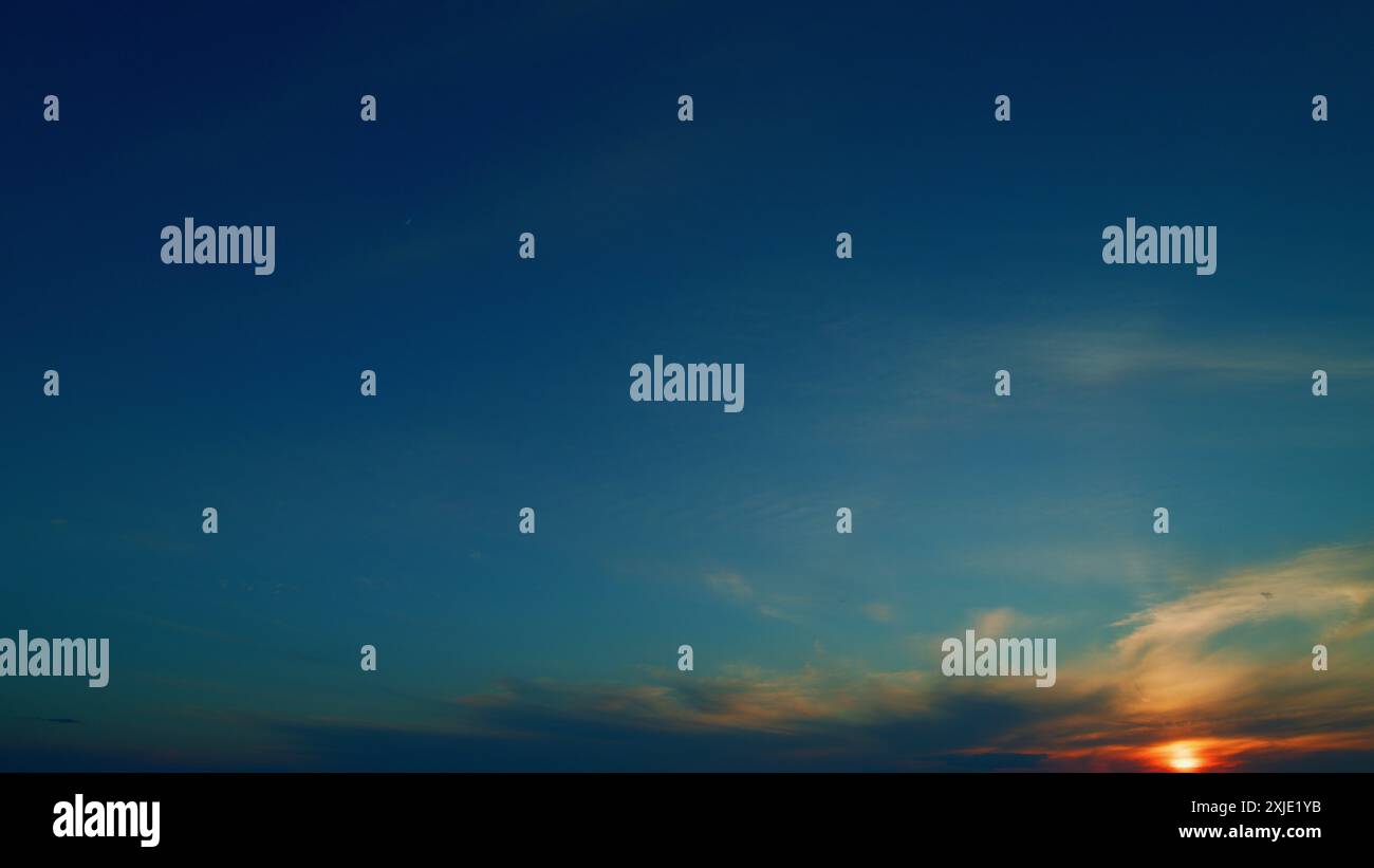 Time lapse. Crescent moon rising. Cloud with purple shadow in blue sky ...