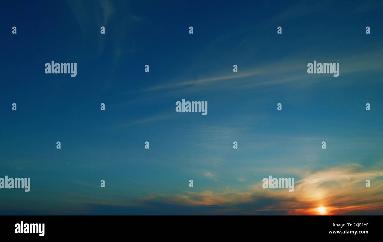 Time lapse. Beautiful blue and orange cloudy sunset sky with halo ...