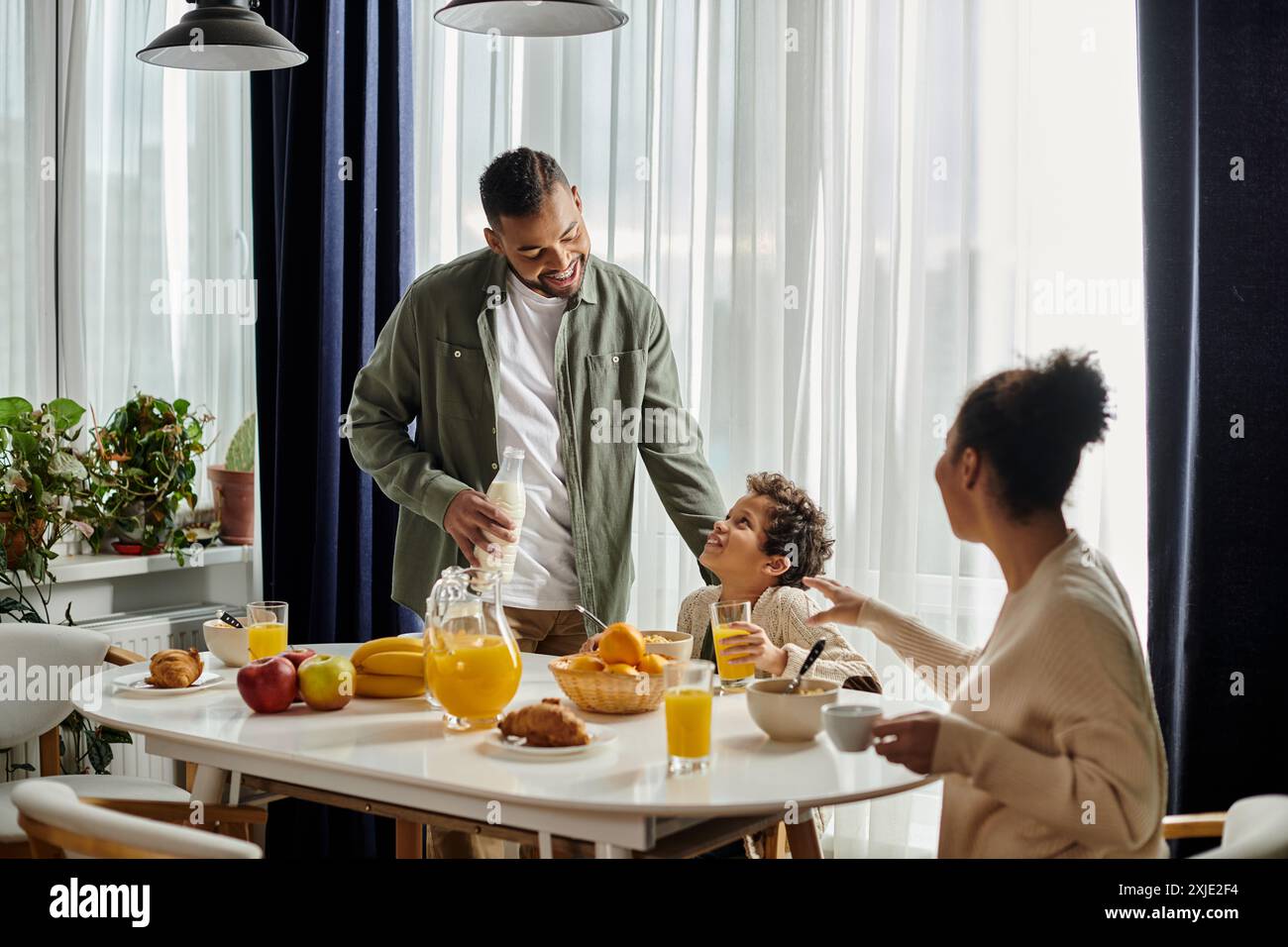A man standing over a table overflowing with delicious food, wife and ...