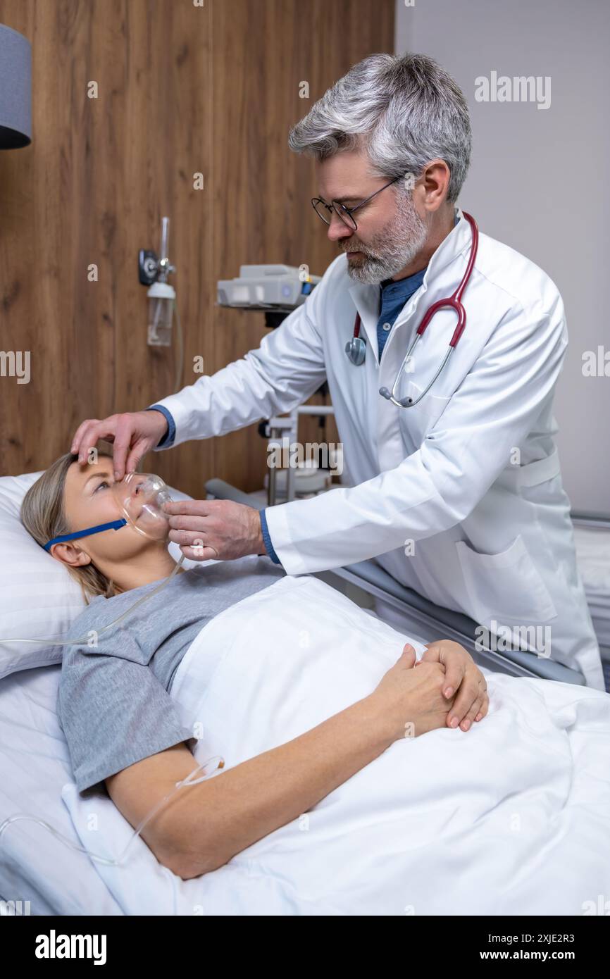 Doctor putting an oxygen mask on a female patient Stock Photo - Alamy